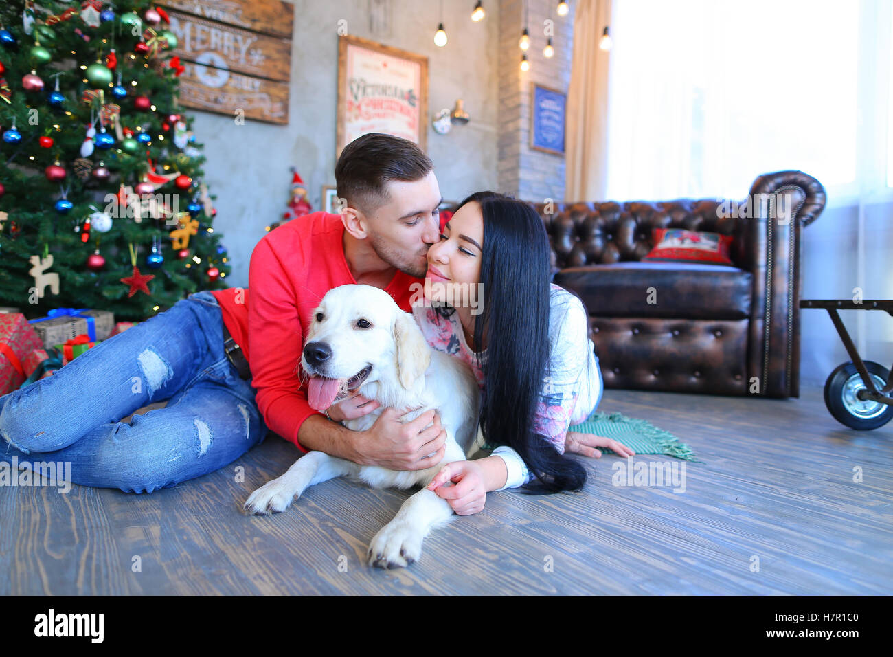 Bride and groom kissing, posing at camera, beside Labrador dog in ...