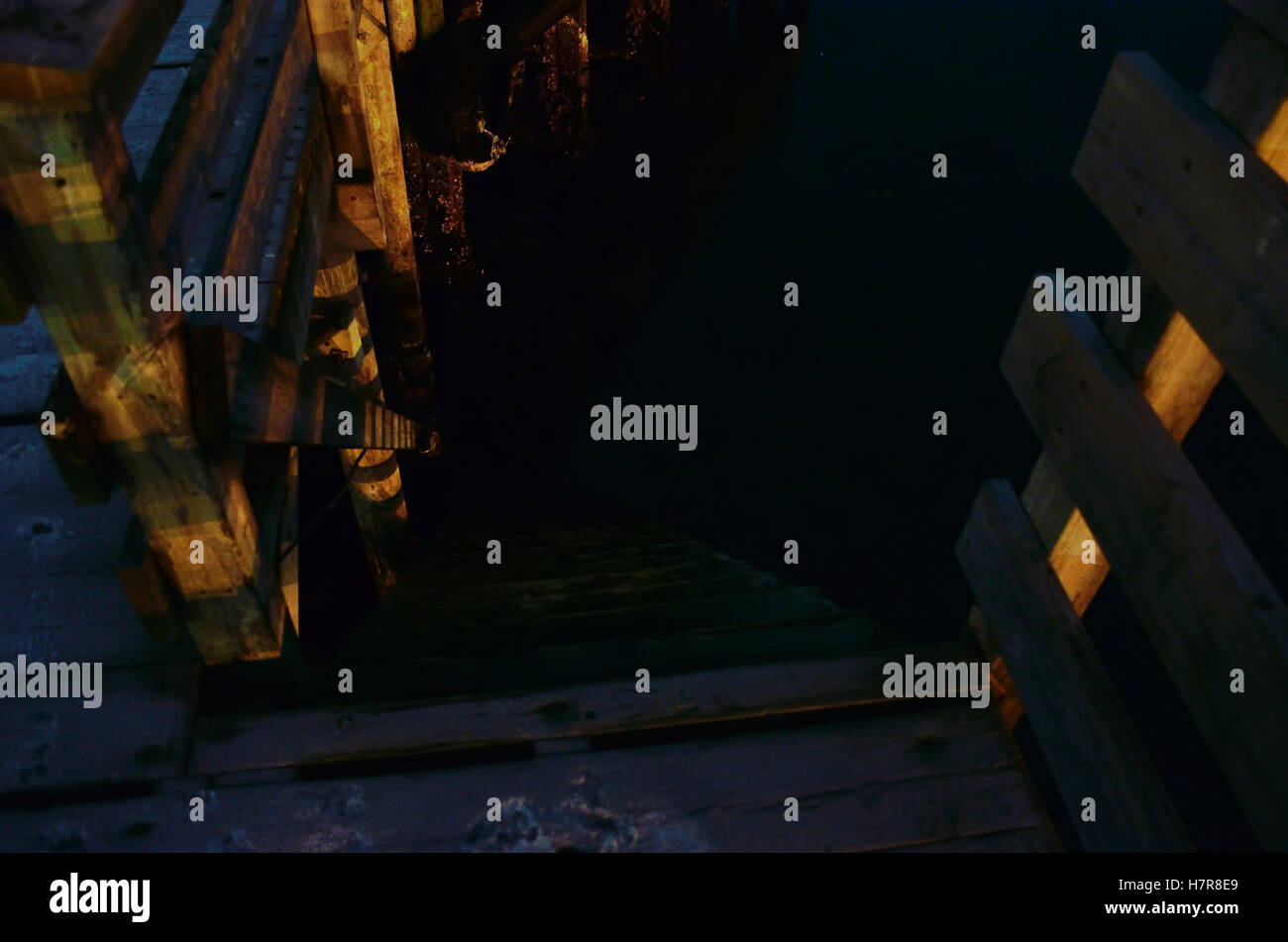 steep wooden pier staircase leading down to sea level at night Stock ...