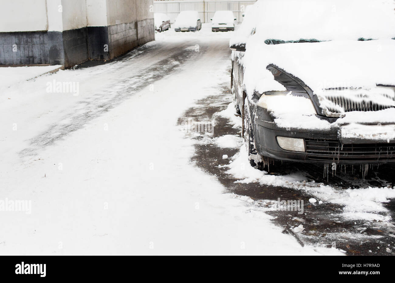 Car under a pile of snow, mixed snow and sleet weather conditions ...