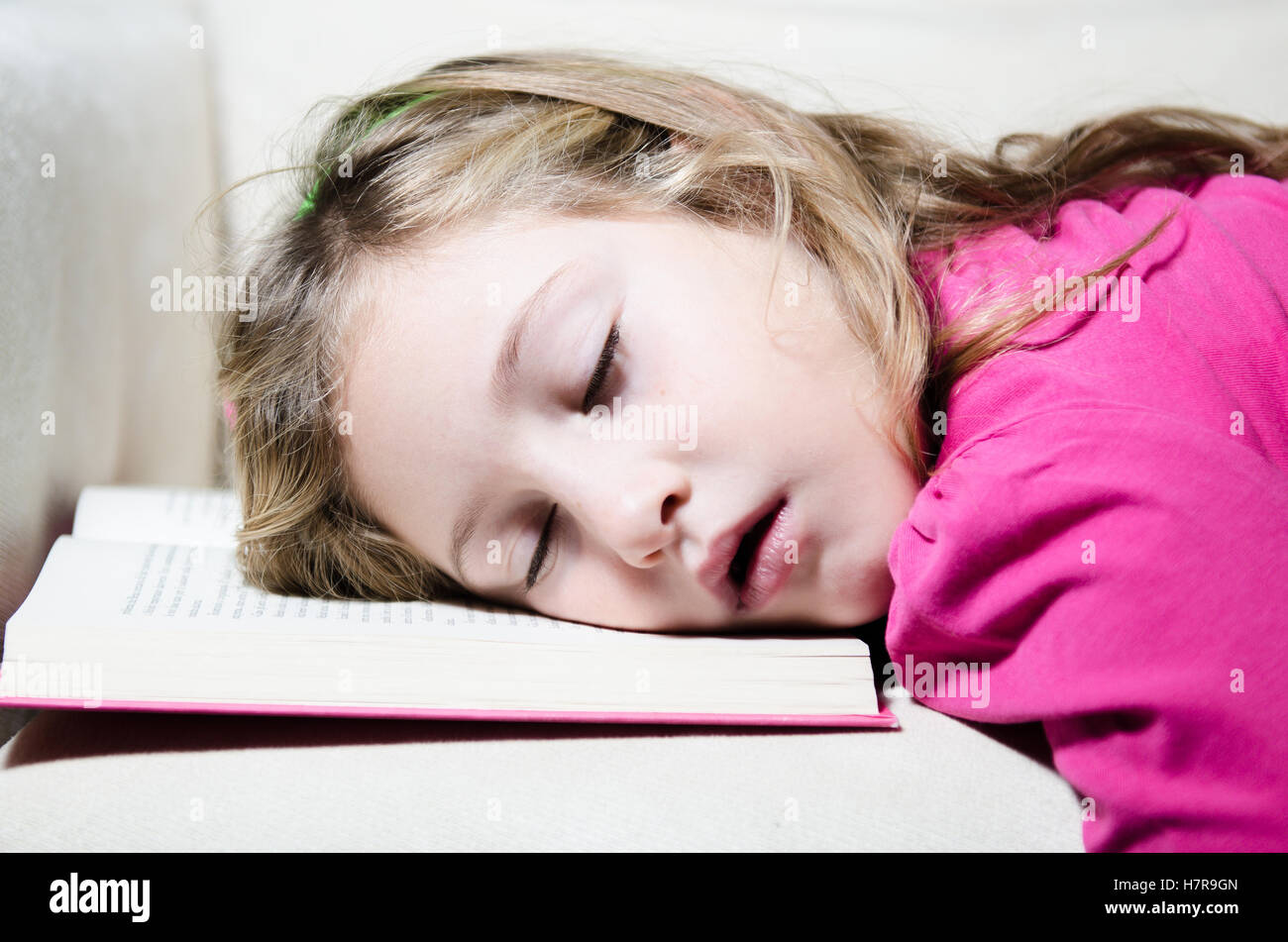 young girl sleeping while reading in the living room at home Stock ...