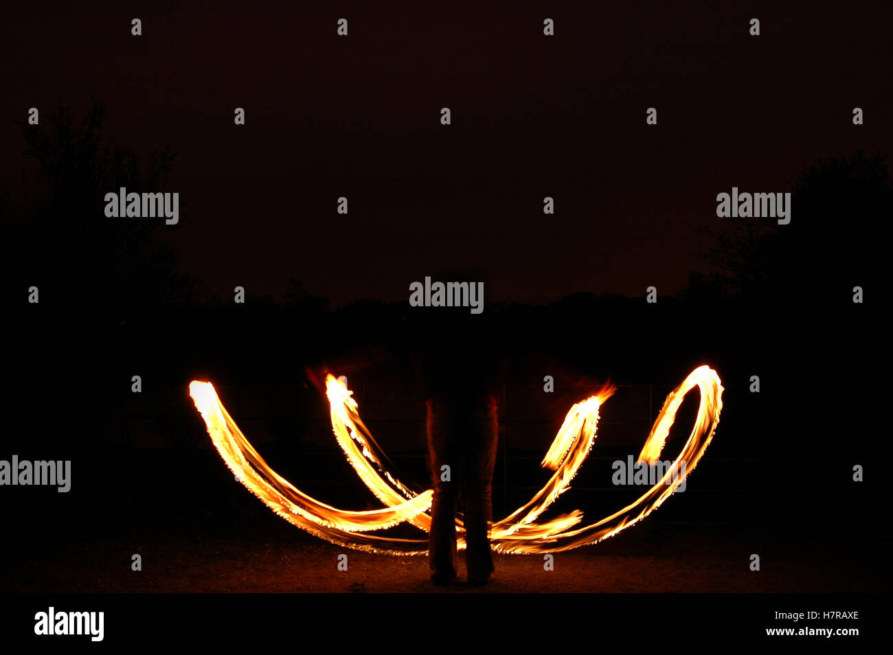 Spinning fire poi Stock Photo - Alamy