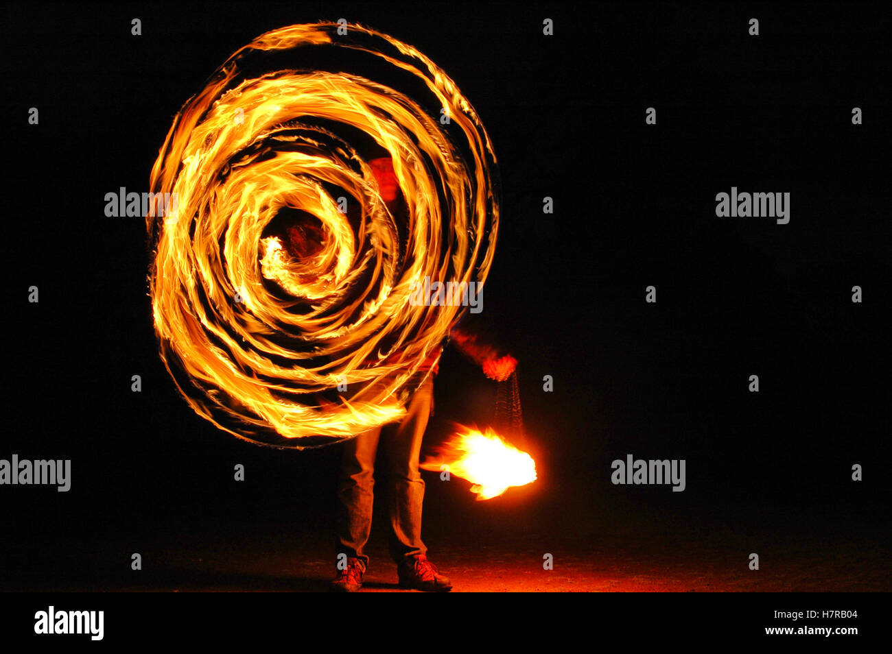 Spinning fire poi Stock Photo - Alamy