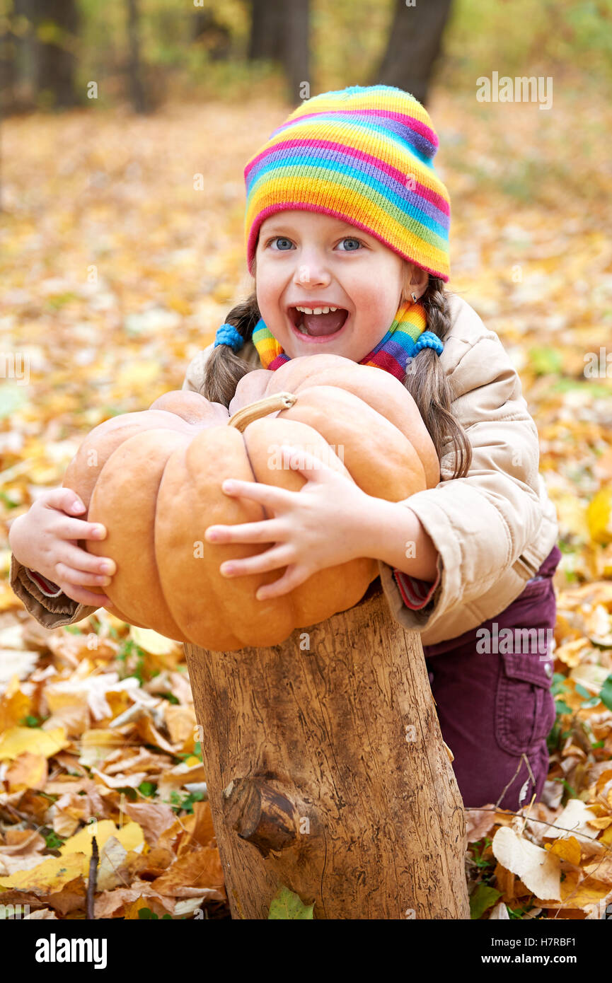 girl child in autumn forest with pumpkin and apples, beautiful ...