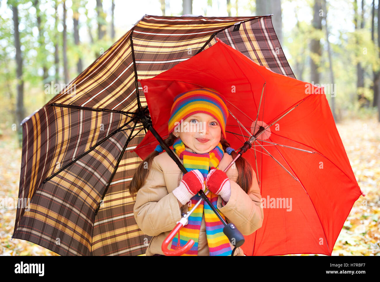 girl child in autumn forest with umbrella, beautiful landscape in fall ...