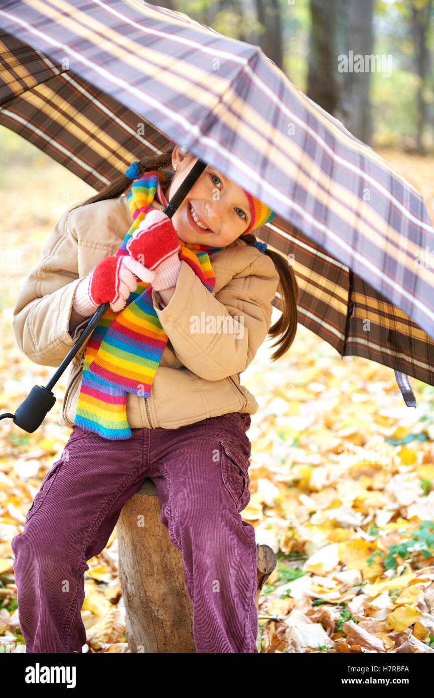 girl child in autumn forest with umbrella, beautiful landscape in fall ...
