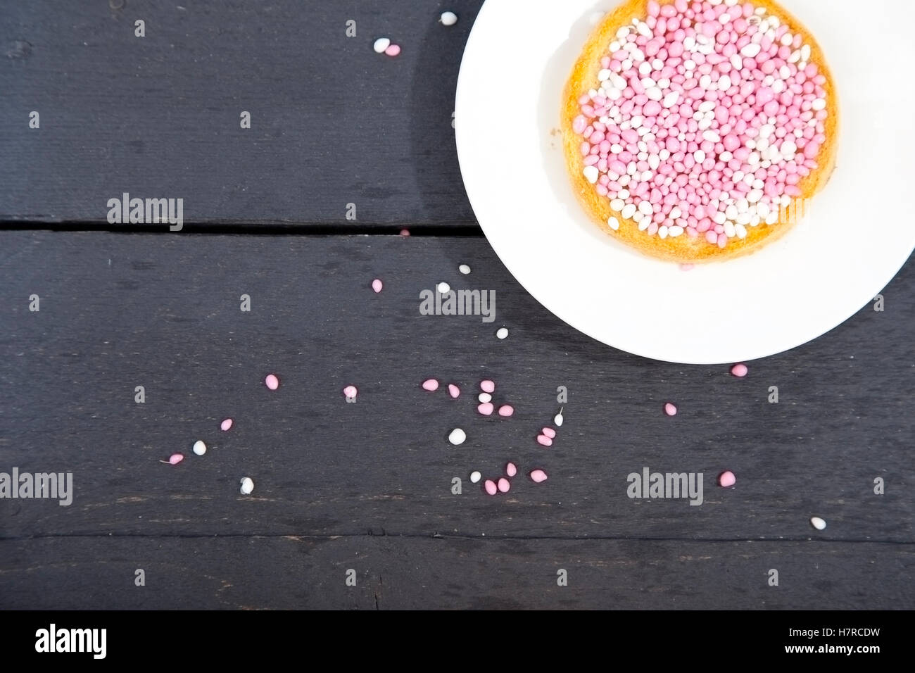 Traditional Dutch birth celebration biscuit with pink muisjes on wooden ...