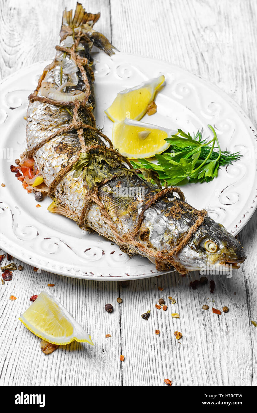 whole carcass of fish grilled on light plate on light background Stock ...