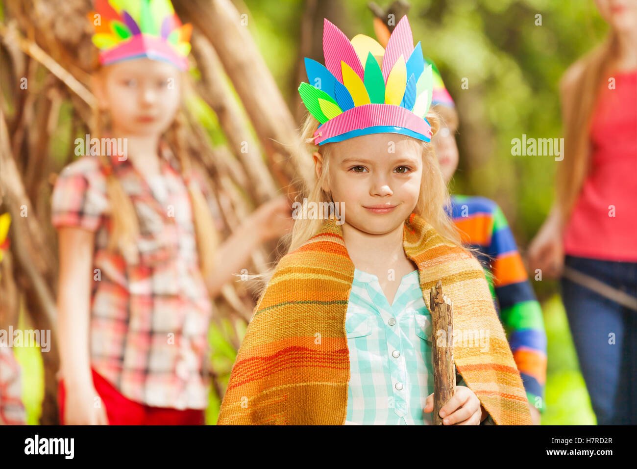 Blond girl in Injun's costume playing with friends Stock Photo - Alamy