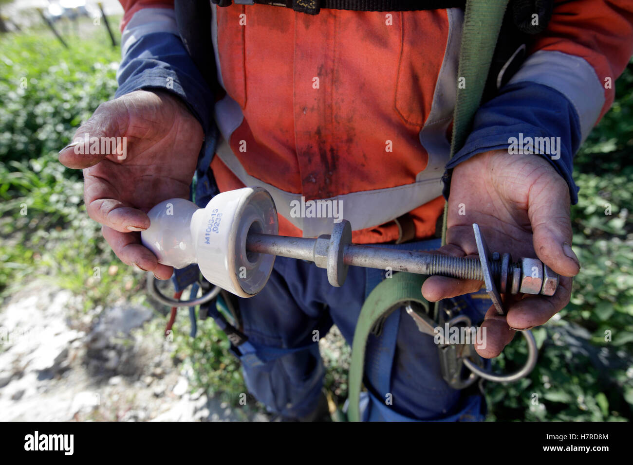 power company worker holding an insulator Stock Photo - Alamy