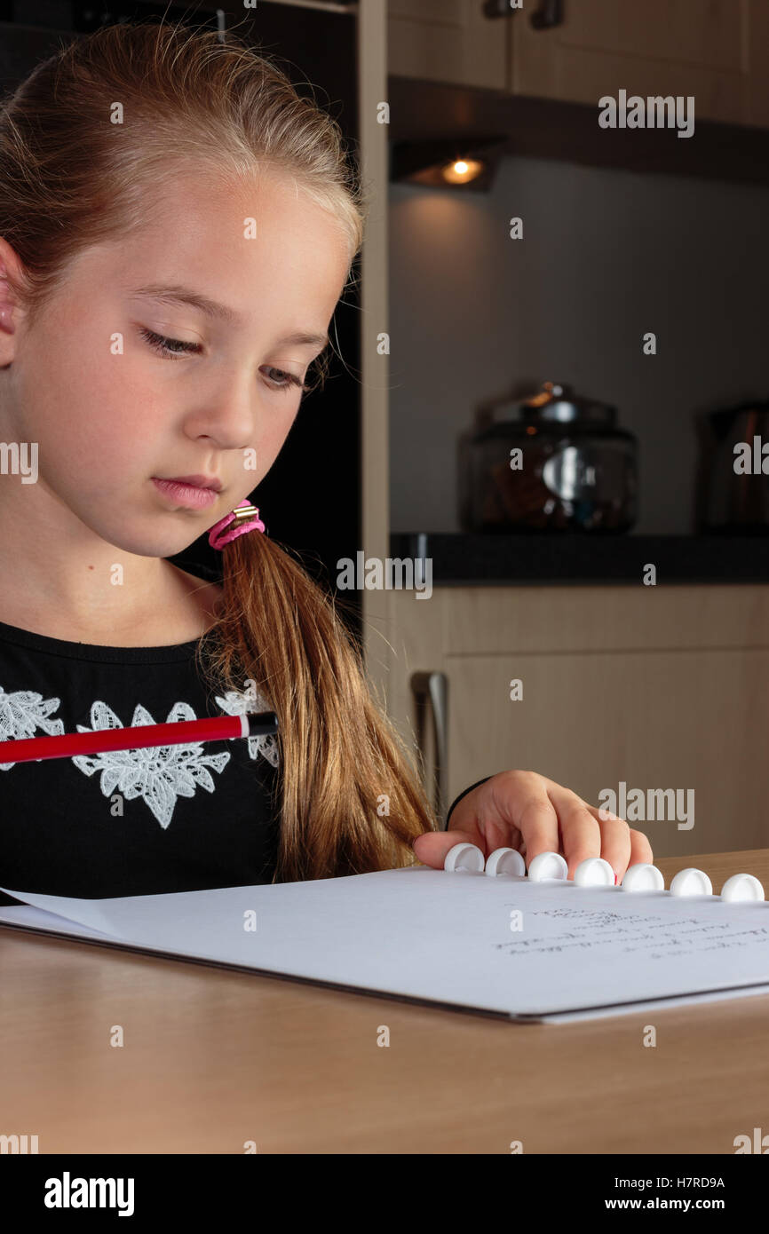 Young girl doing homework at the kitchen table Stock Photo - Alamy