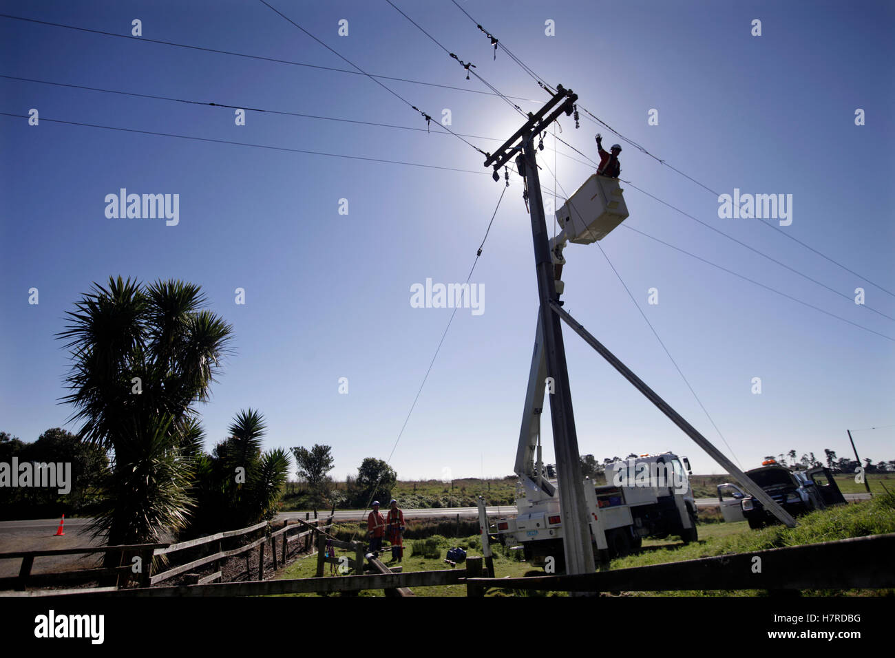 power company workers using a cherry picker hoist replacing high ...