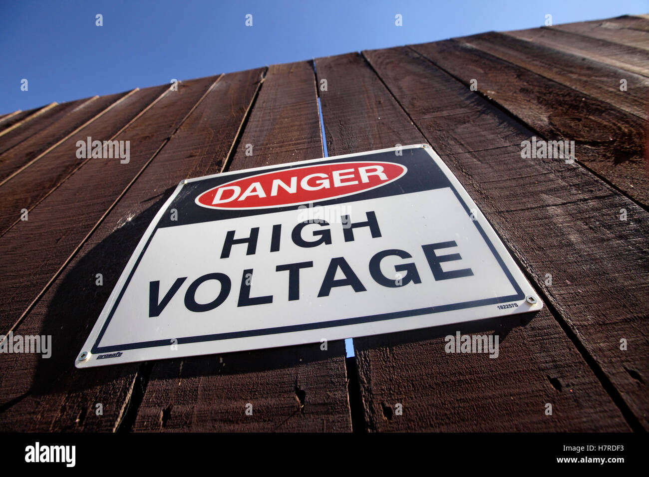 High voltage warning sign on wooden fence at a substation in New ...