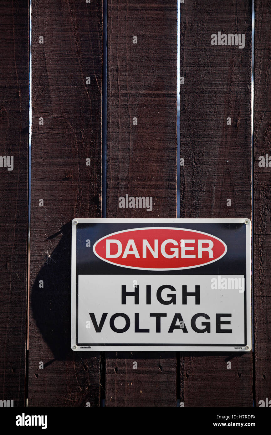 High voltage warning sign on wooden fence at a substation in New ...