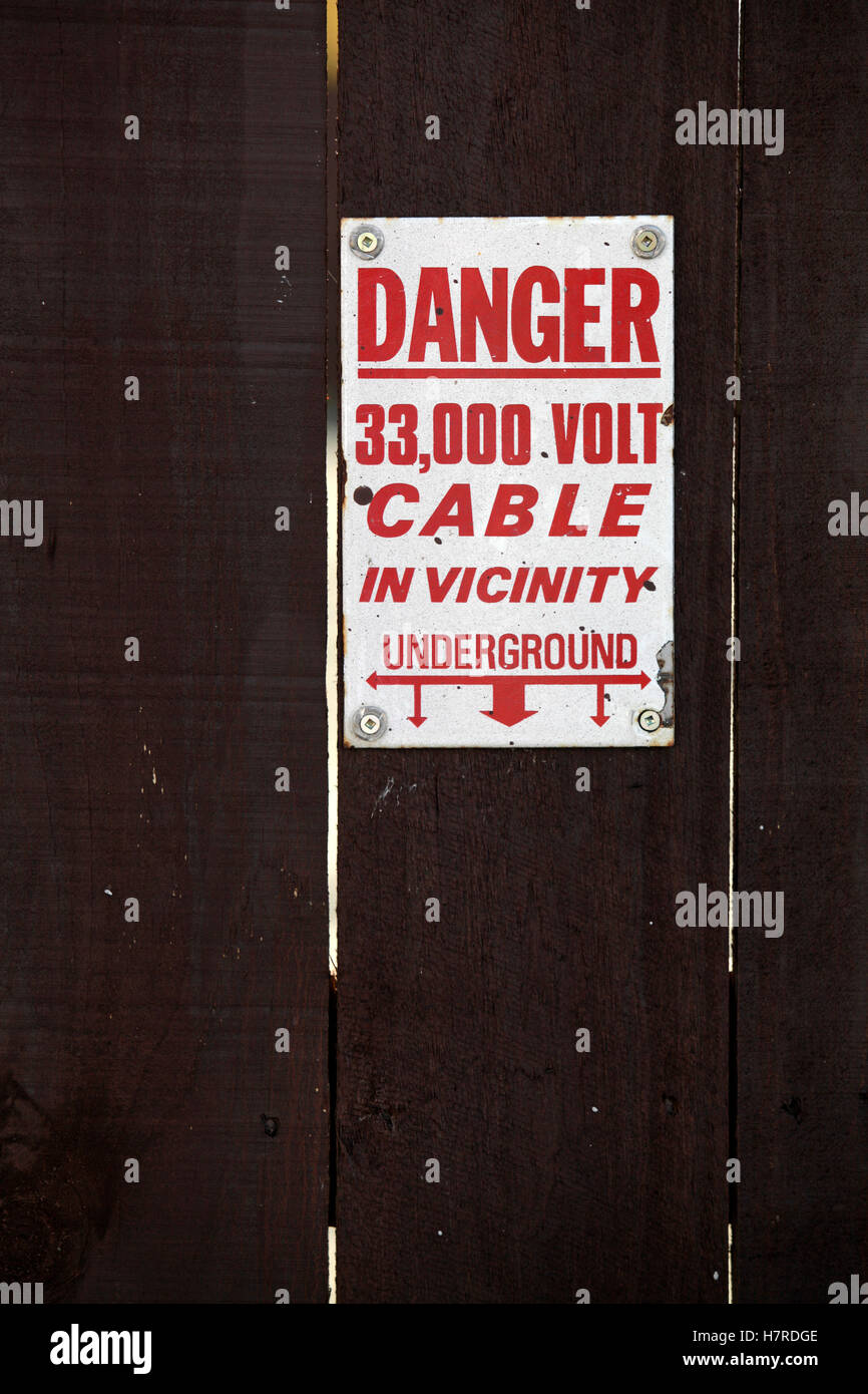 High voltage warning sign on wooden fence at a substation in New ...