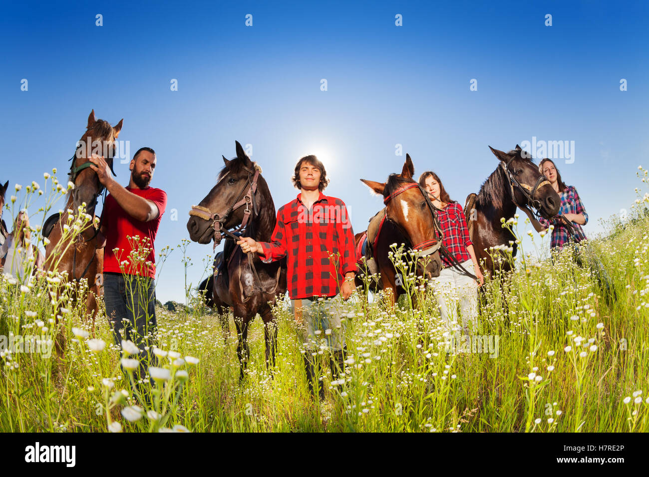 Four happy equestrians walking with their horses Stock Photo - Alamy