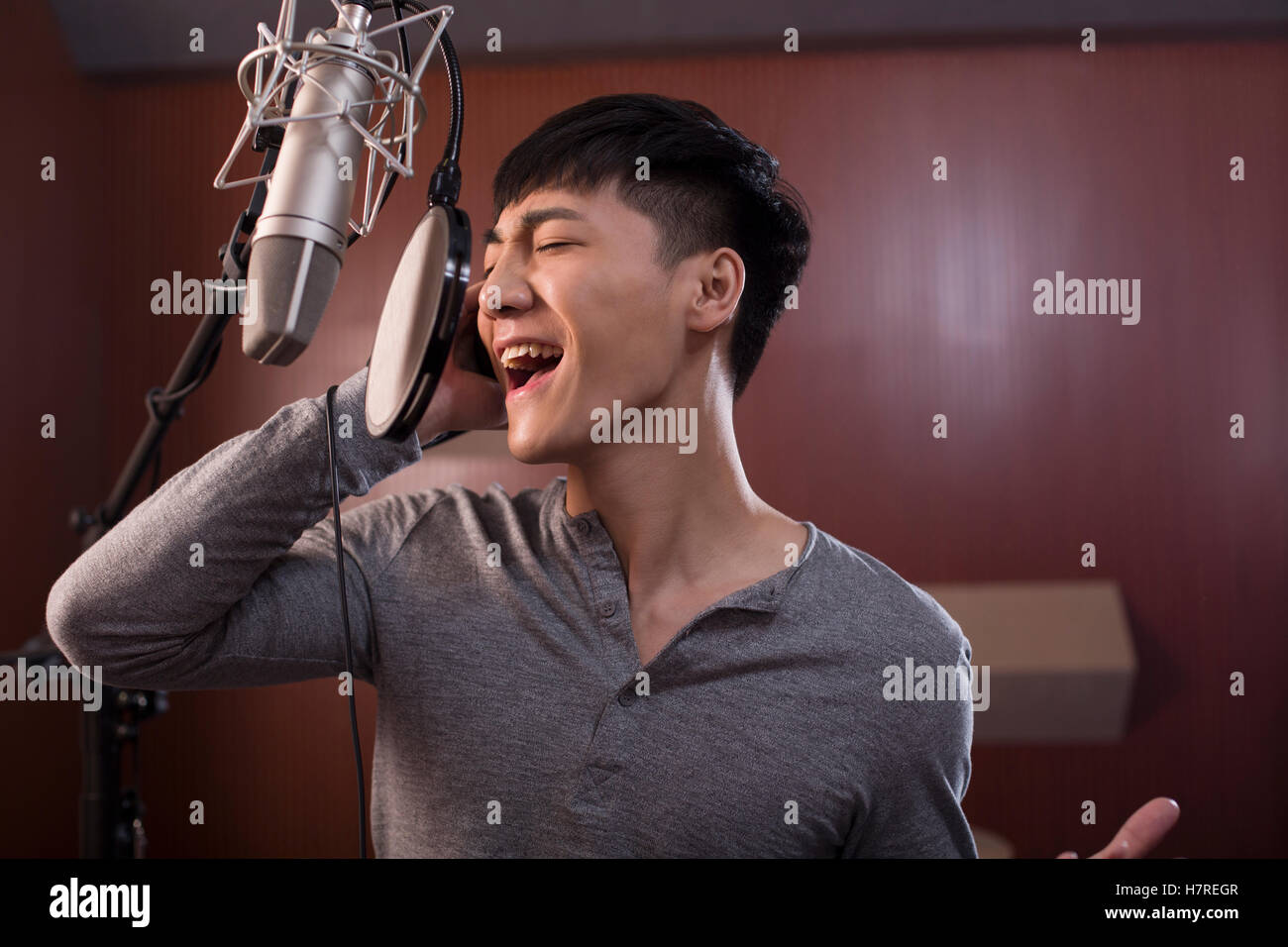Young Chinese man singing in recording studio Stock Photo - Alamy