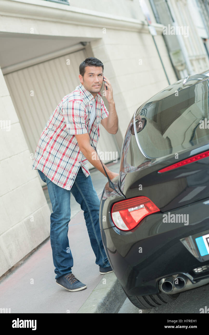 Man getting into car, on cellphone Stock Photo - Alamy