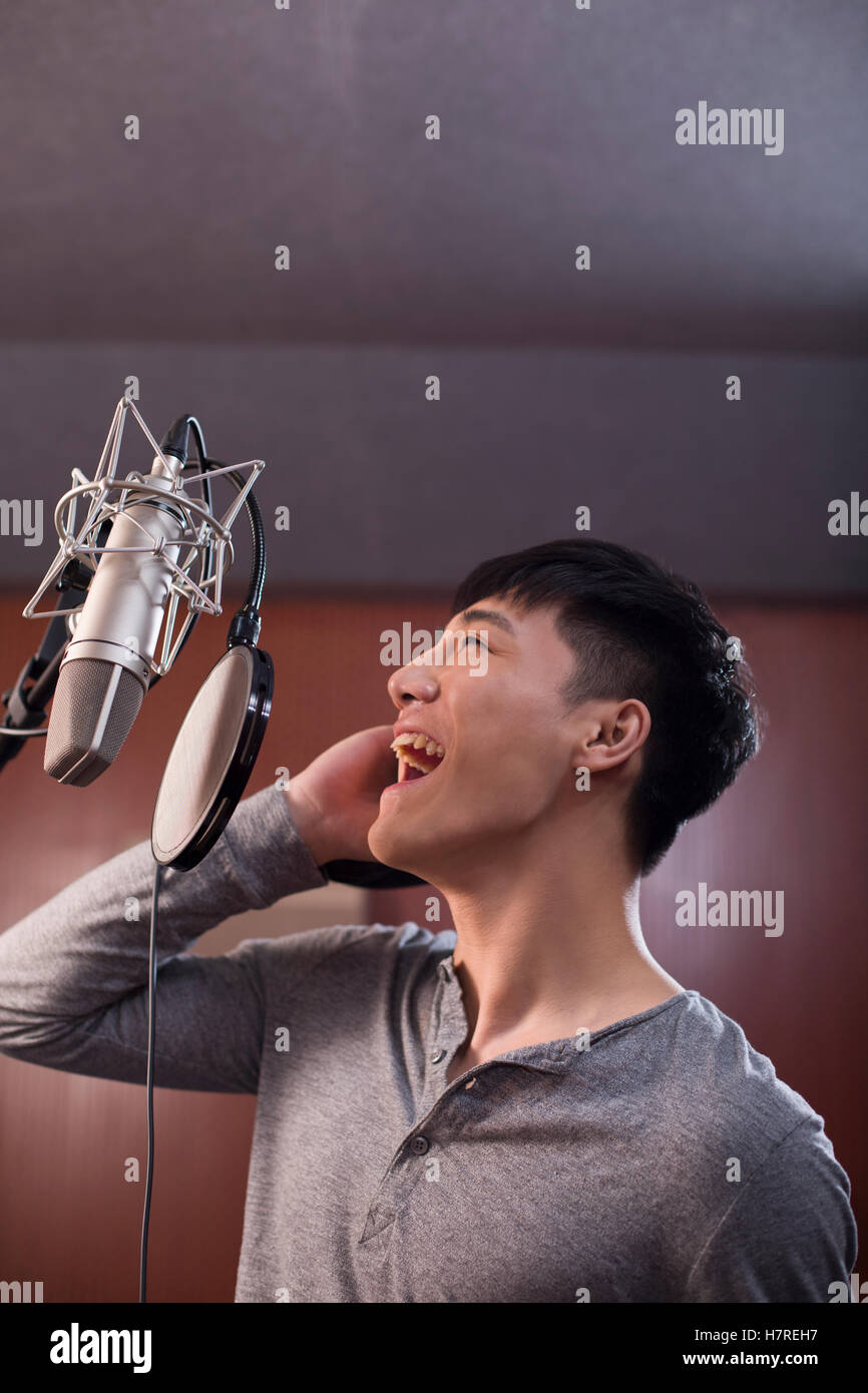 Young Chinese man singing in recording studio Stock Photo - Alamy