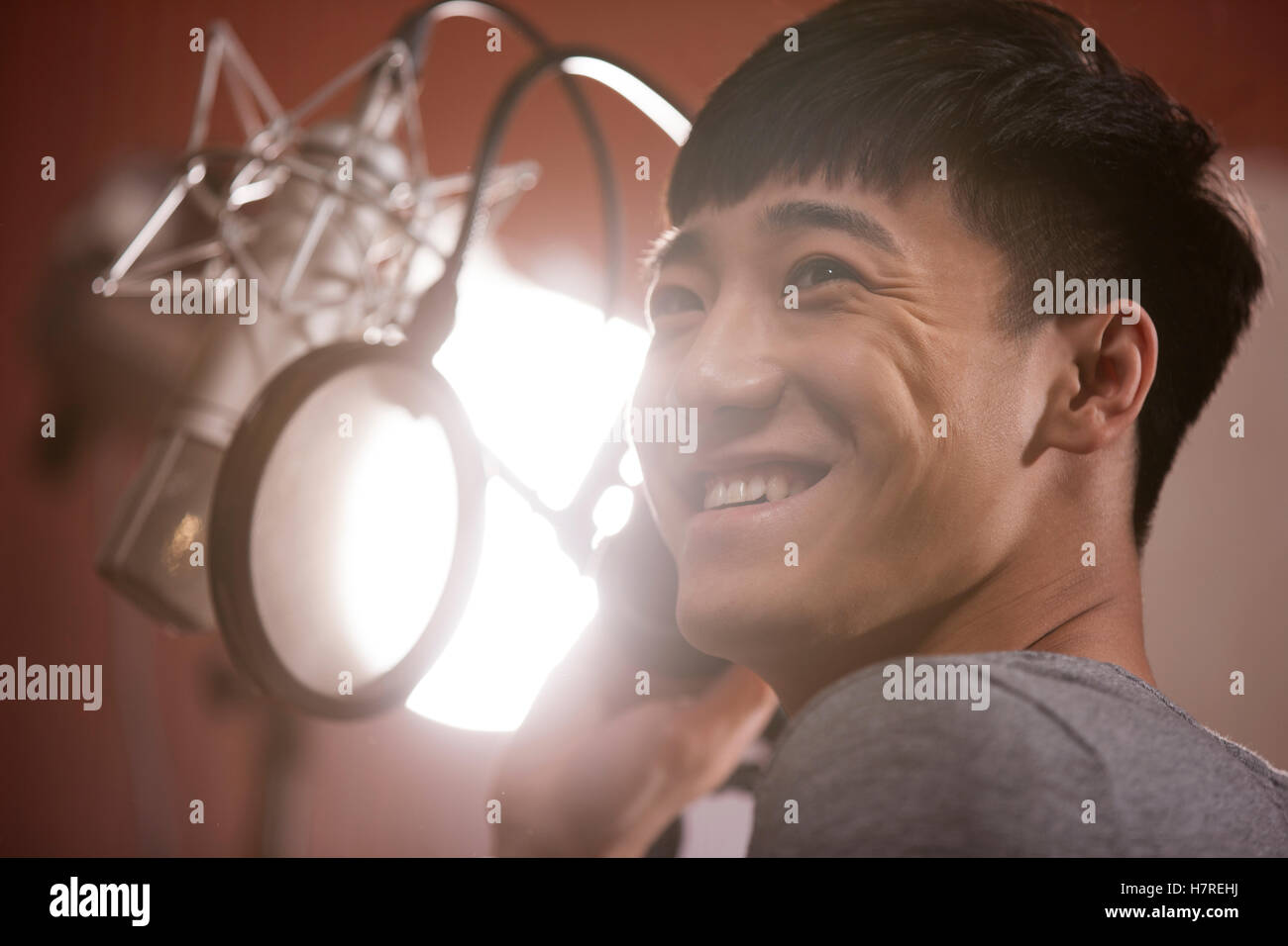 Young Chinese man singing in recording studio Stock Photo - Alamy