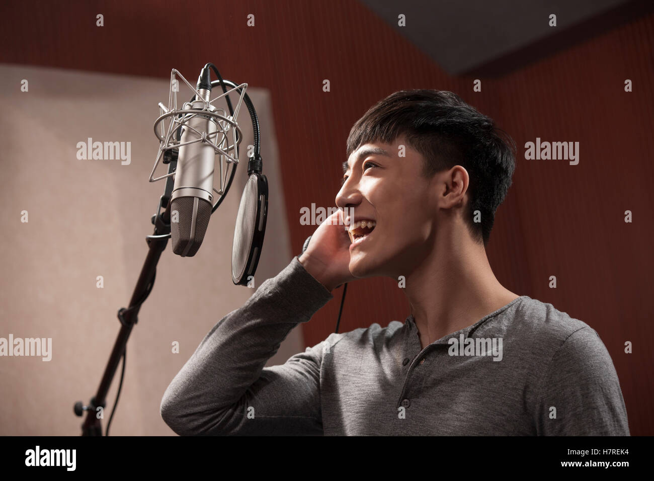 Young Chinese man singing in recording studio Stock Photo - Alamy