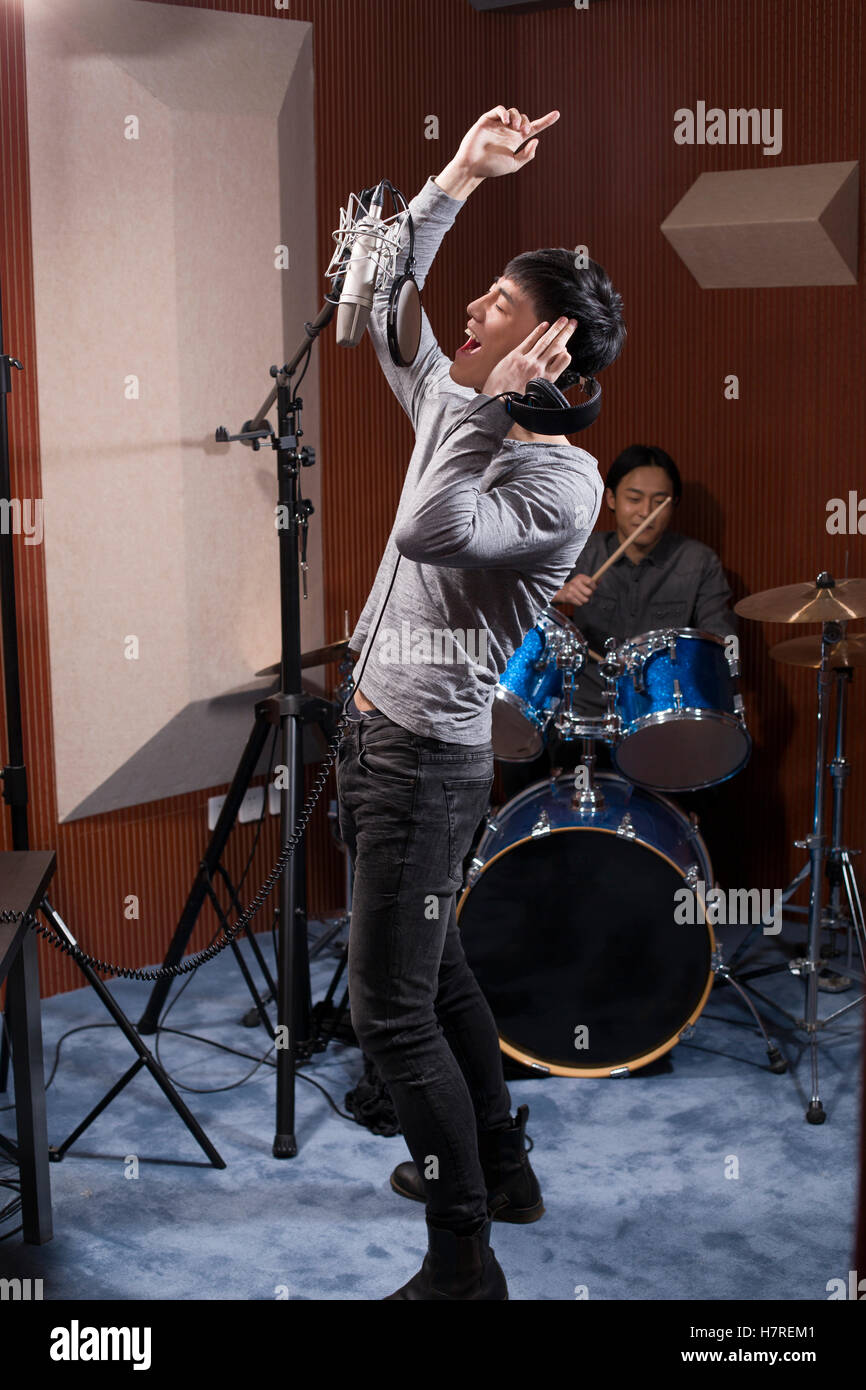 Young Chinese man singing in recording studio Stock Photo - Alamy