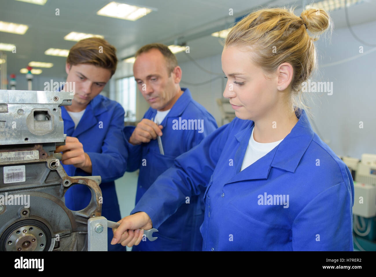 Woman adjusting machine with spanner Stock Photo - Alamy