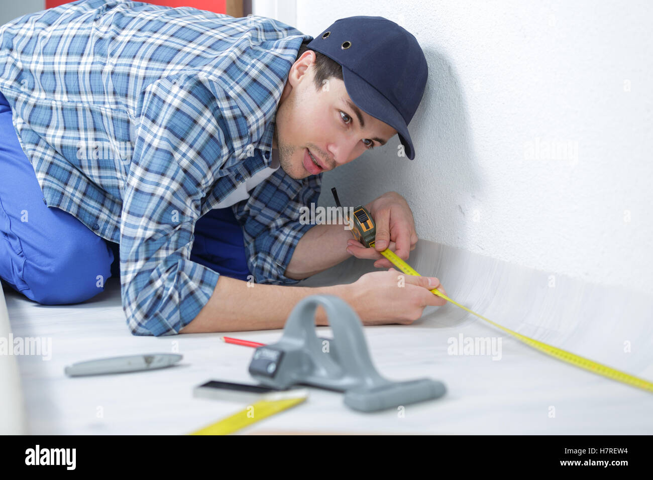 handyman measuring unfinished room in new house Stock Photo - Alamy