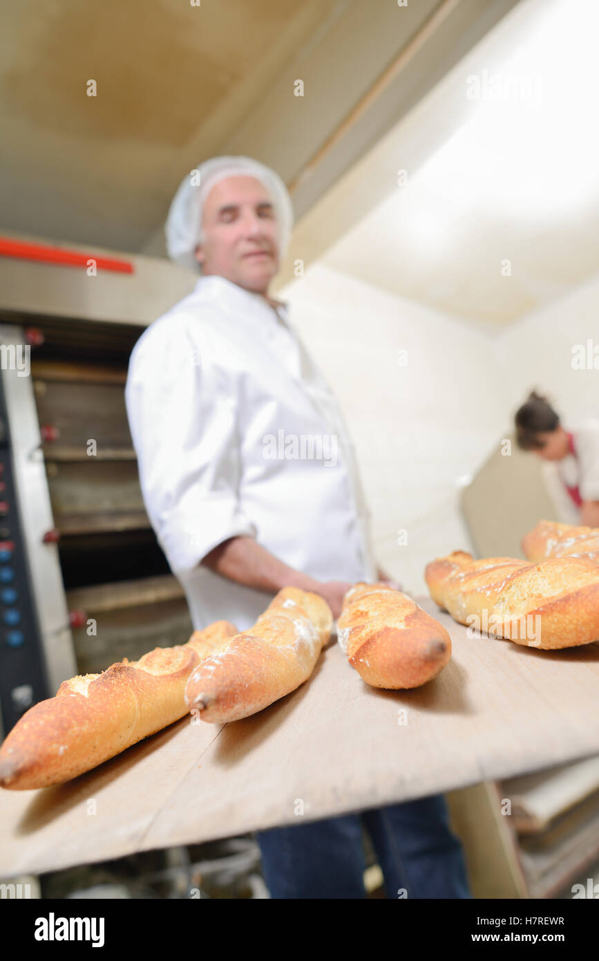 Baker holding five baguettes on paddle Stock Photo - Alamy