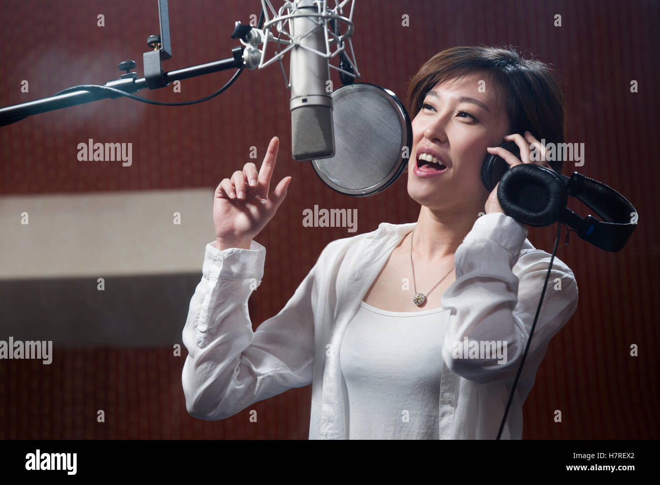 Young Chinese woman singing in recording studio Stock Photo - Alamy