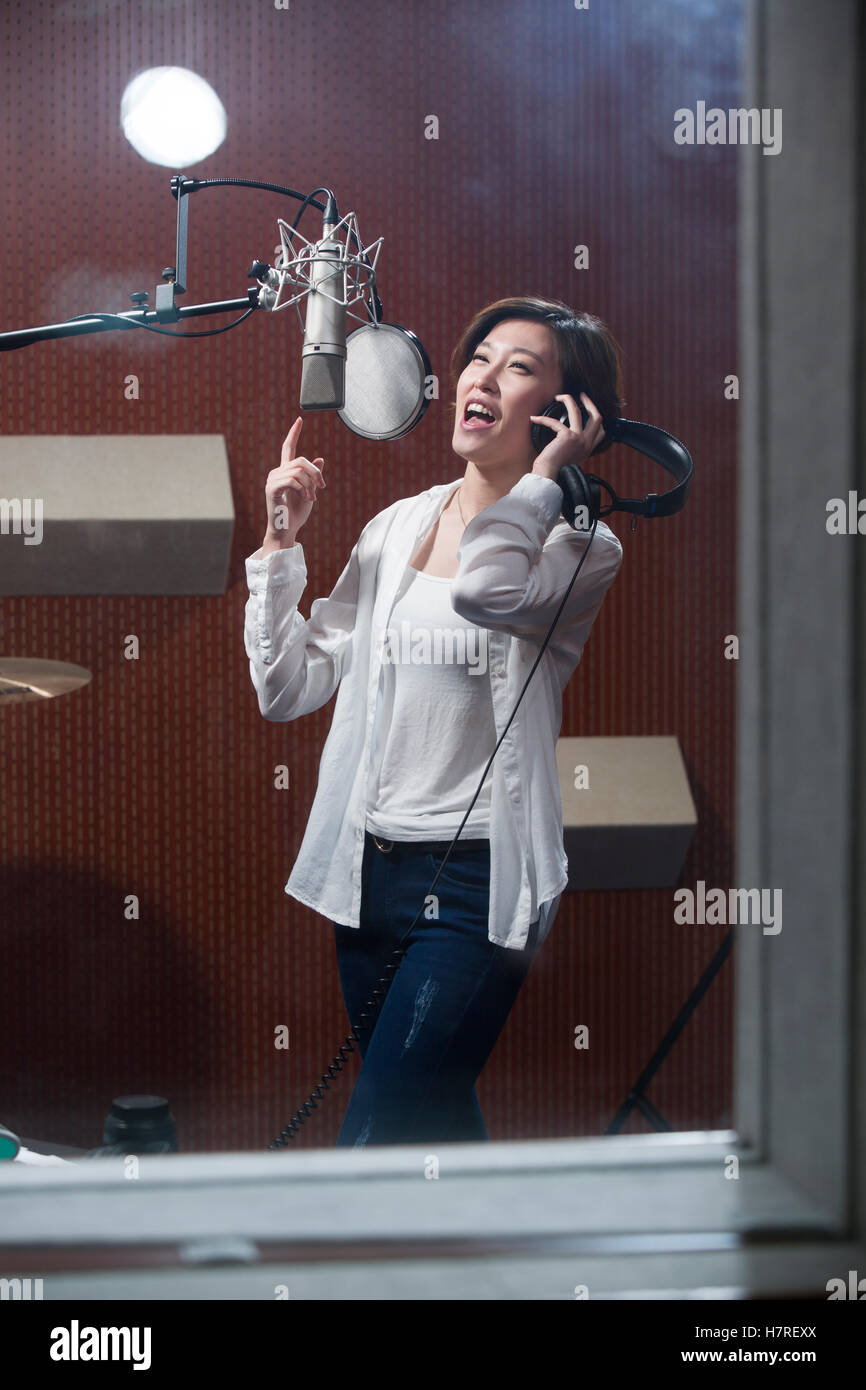 Young Chinese woman singing in recording studio Stock Photo - Alamy