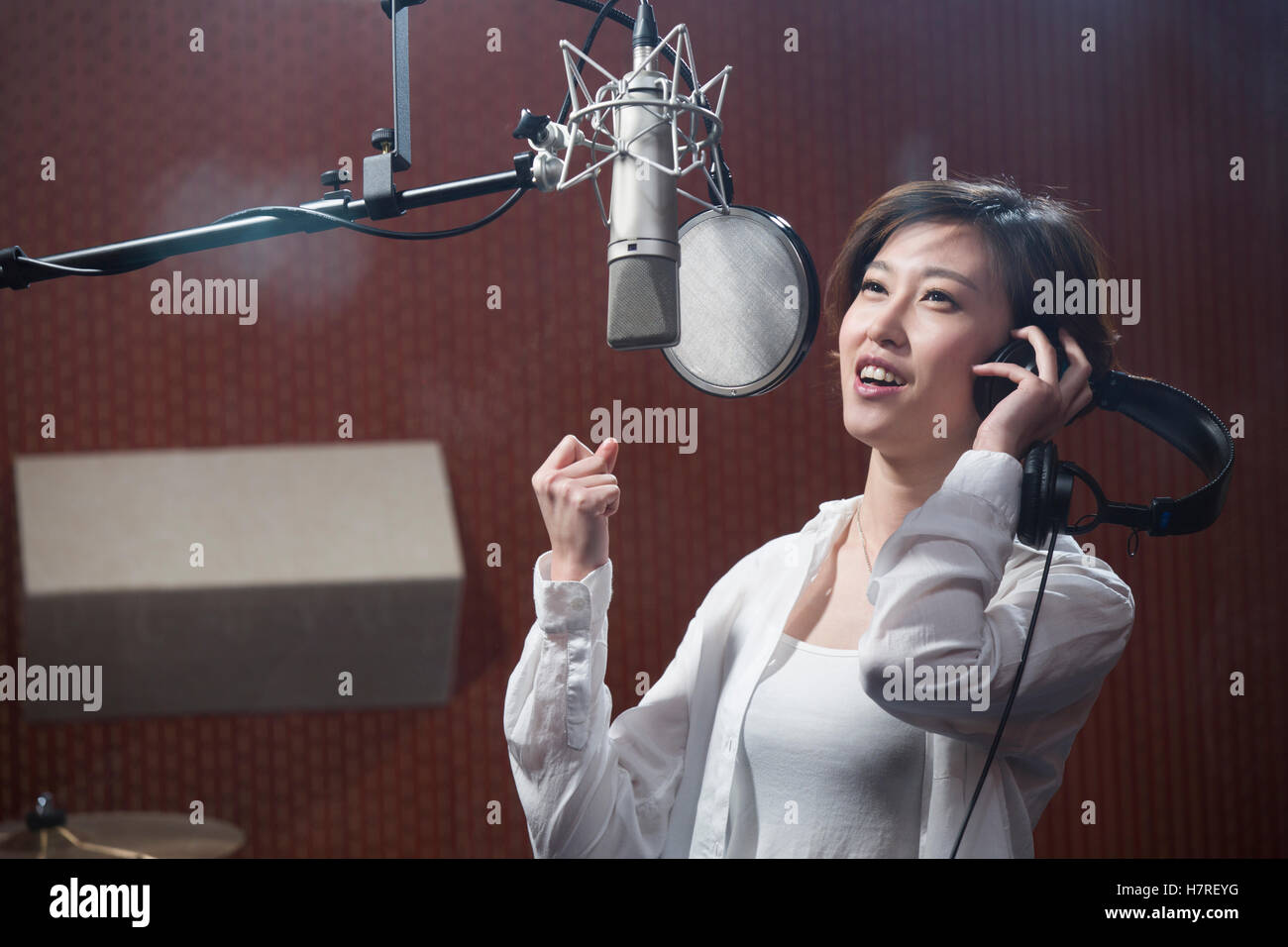 Young Chinese woman singing in recording studio Stock Photo - Alamy
