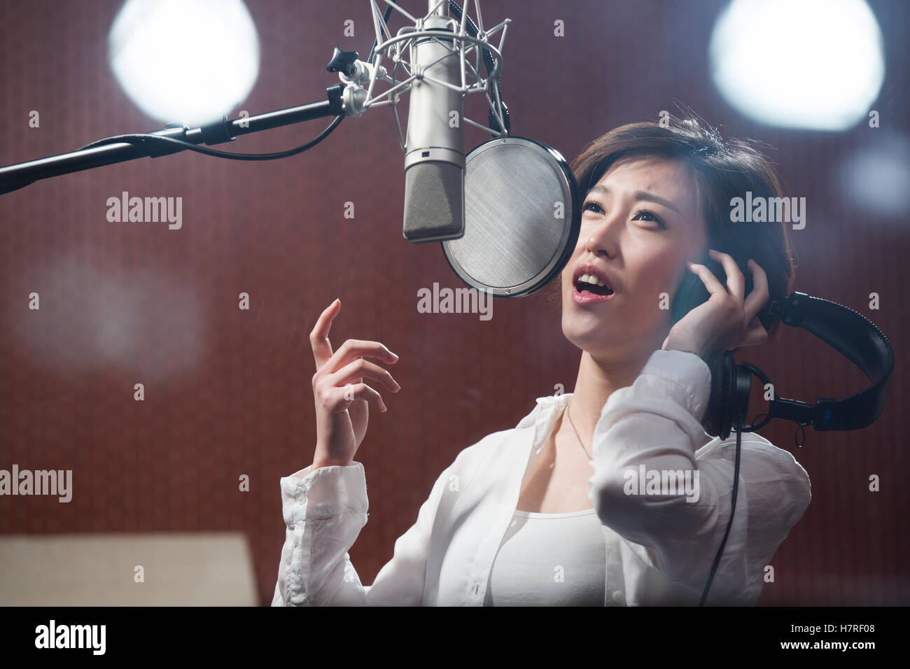 Young Chinese woman singing in recording studio Stock Photo - Alamy