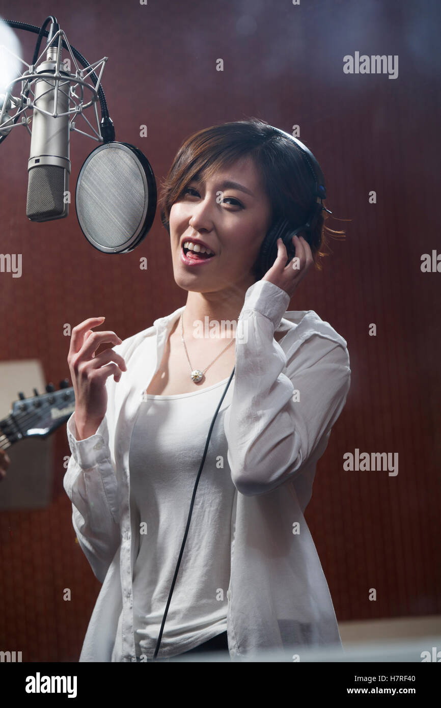 Young Chinese woman singing in recording studio Stock Photo - Alamy