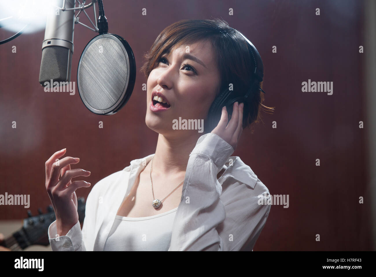 Young Chinese woman singing in recording studio Stock Photo - Alamy
