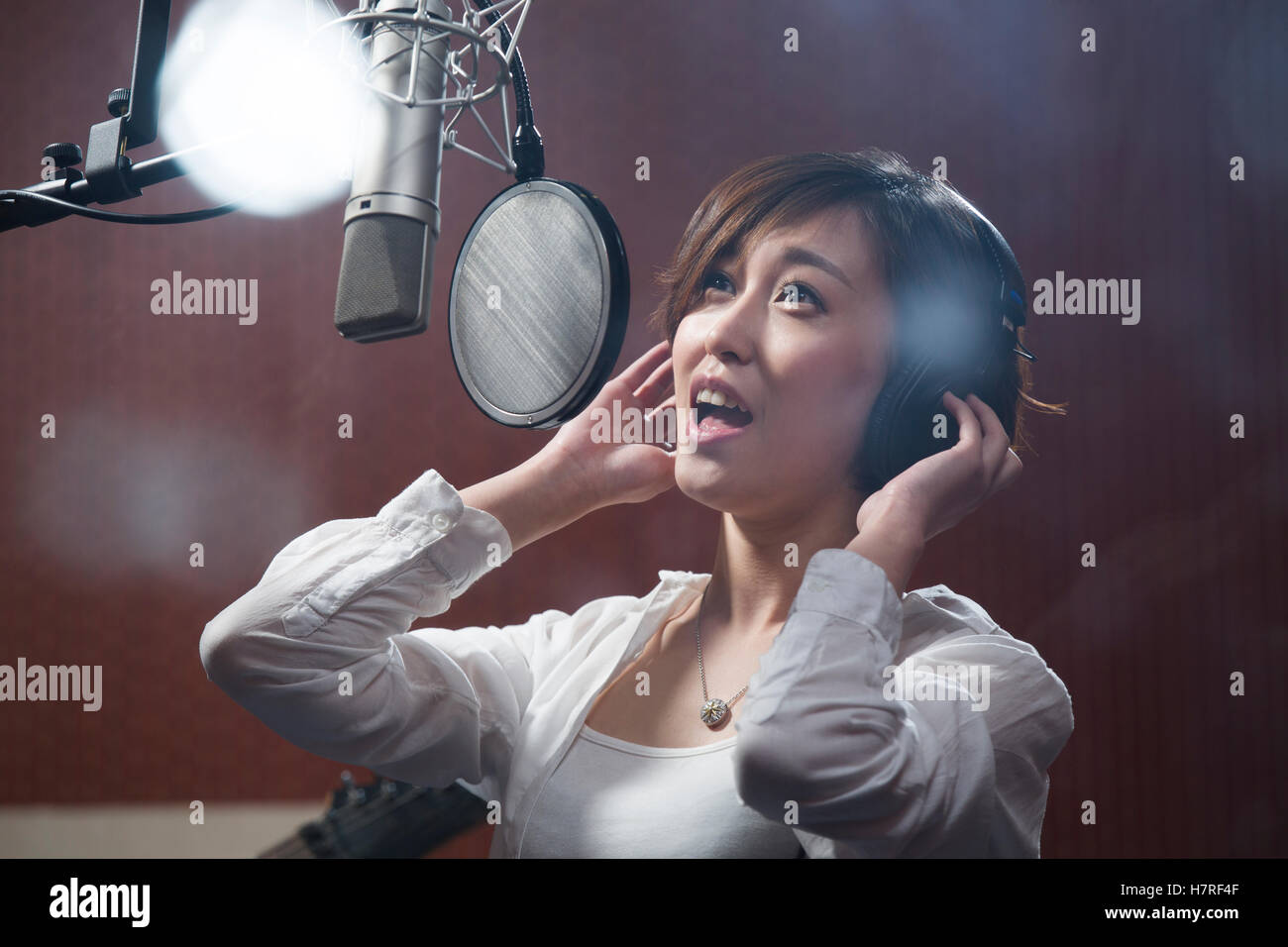 Young Chinese woman singing in recording studio Stock Photo - Alamy