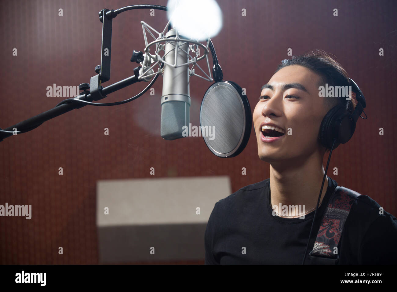 Young Chinese man singing in recording studio Stock Photo - Alamy