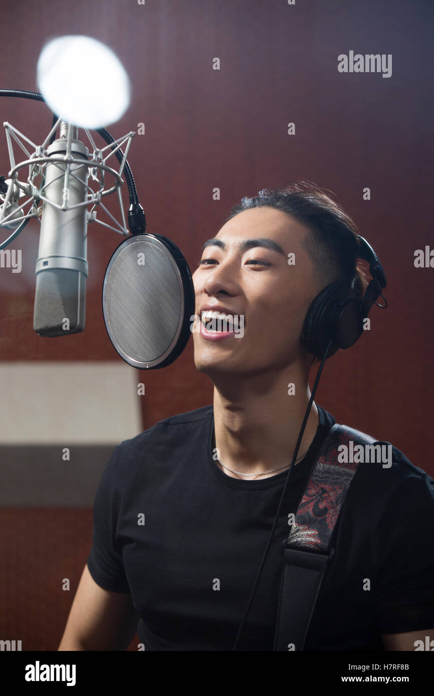 Young Chinese man singing in recording studio Stock Photo - Alamy