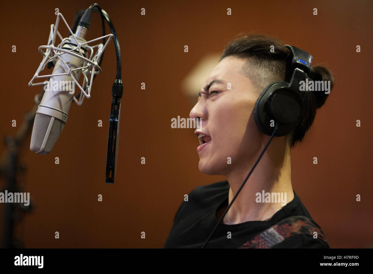 Young Chinese man singing in recording studio Stock Photo - Alamy