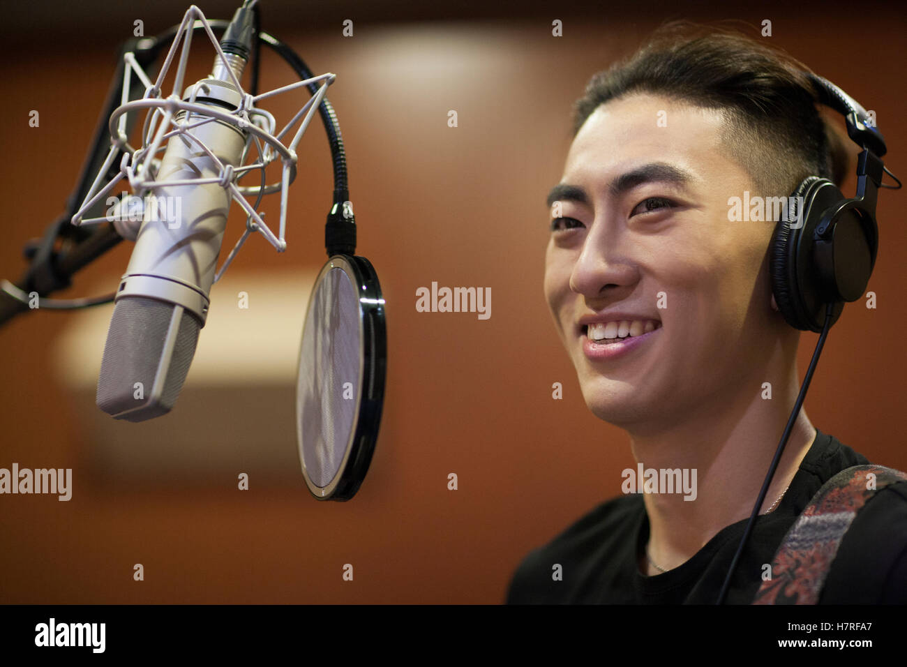 Young Chinese man singing in recording studio Stock Photo - Alamy