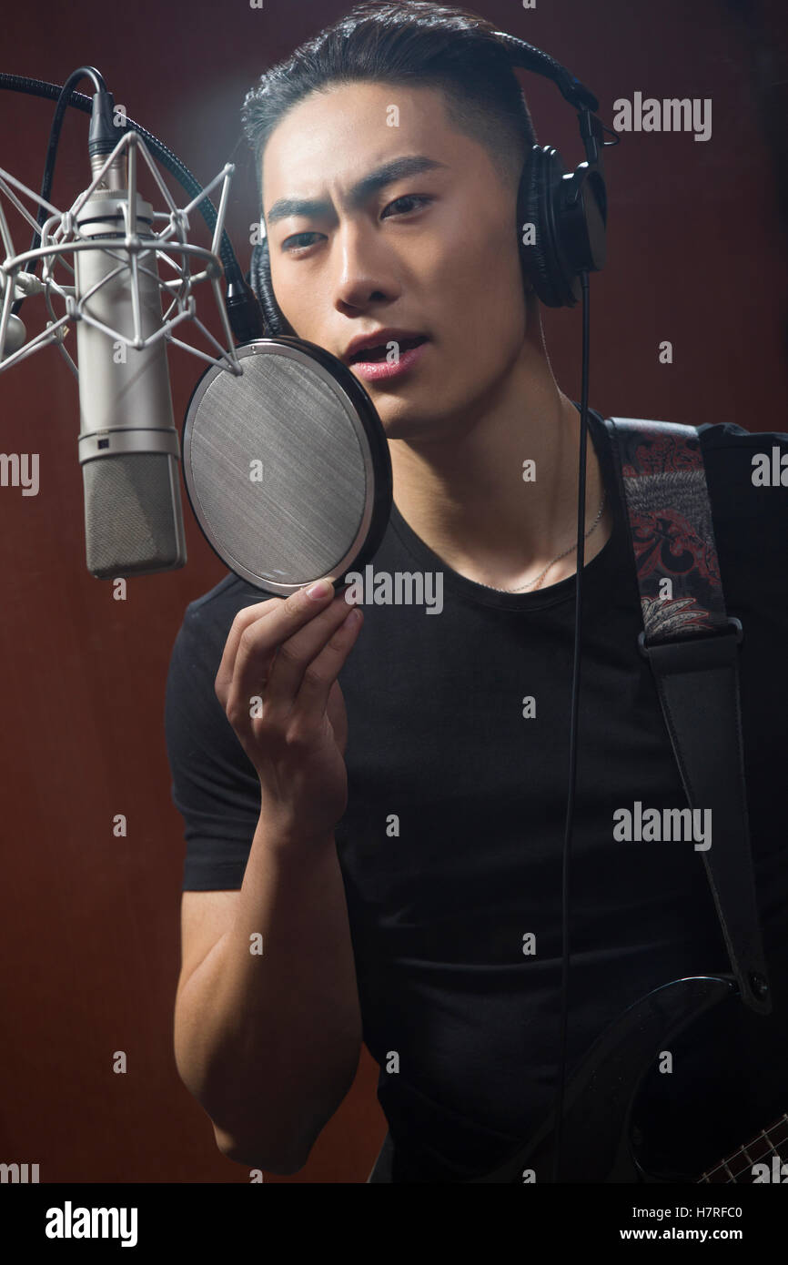 Young Chinese man singing in recording studio Stock Photo - Alamy