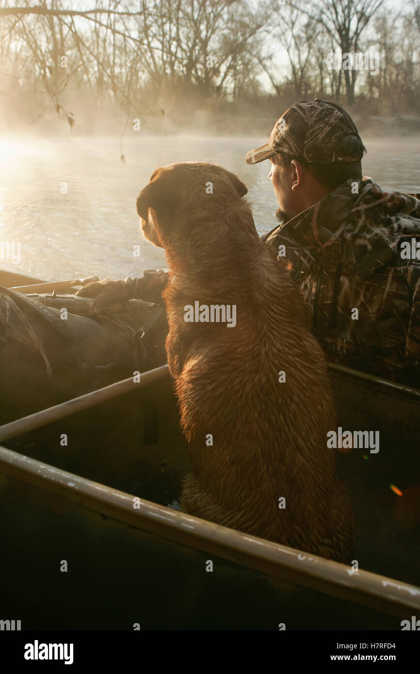Waterfowl Hunter In Boat With Yellow Rusty Lab Stock Photo - Alamy