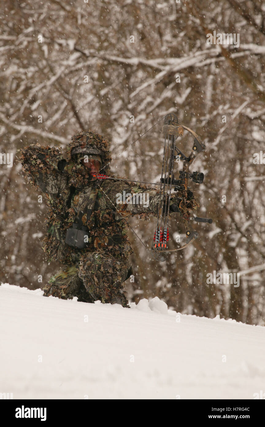 Male Bowhunter Draws Bow In Snow While Deer Hunting Stock Photo - Alamy