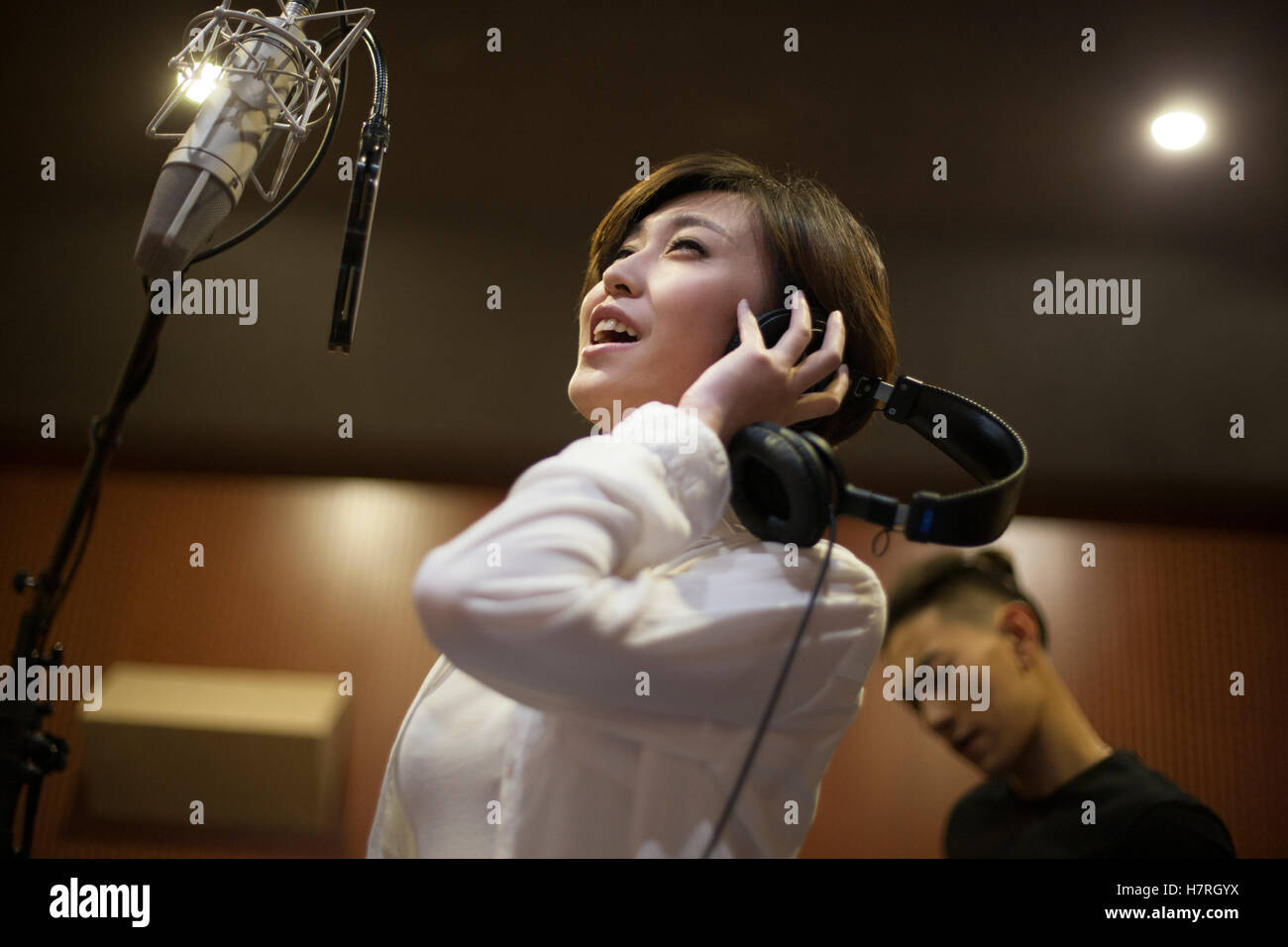 Young Chinese woman singing in recording studio Stock Photo - Alamy