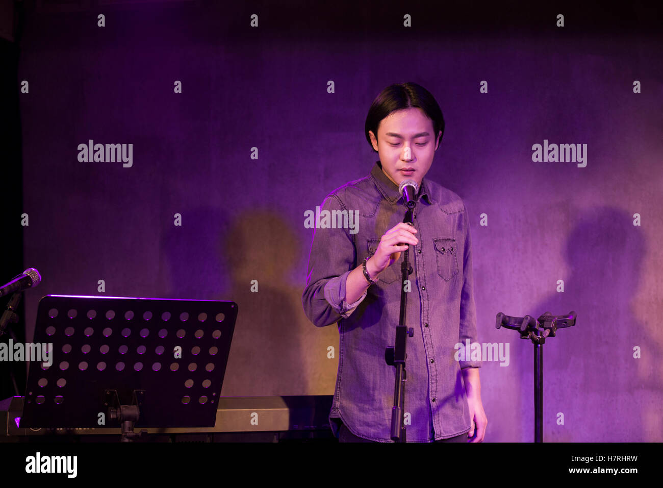 Young Chinese man singing on stage Stock Photo - Alamy