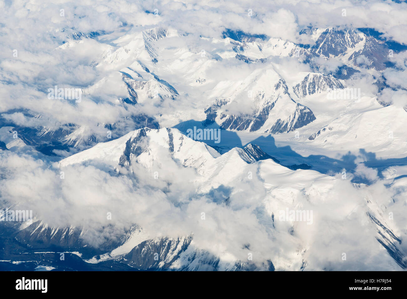 Aerial view of clouds twisting among the snowy peaks of the Alaska ...