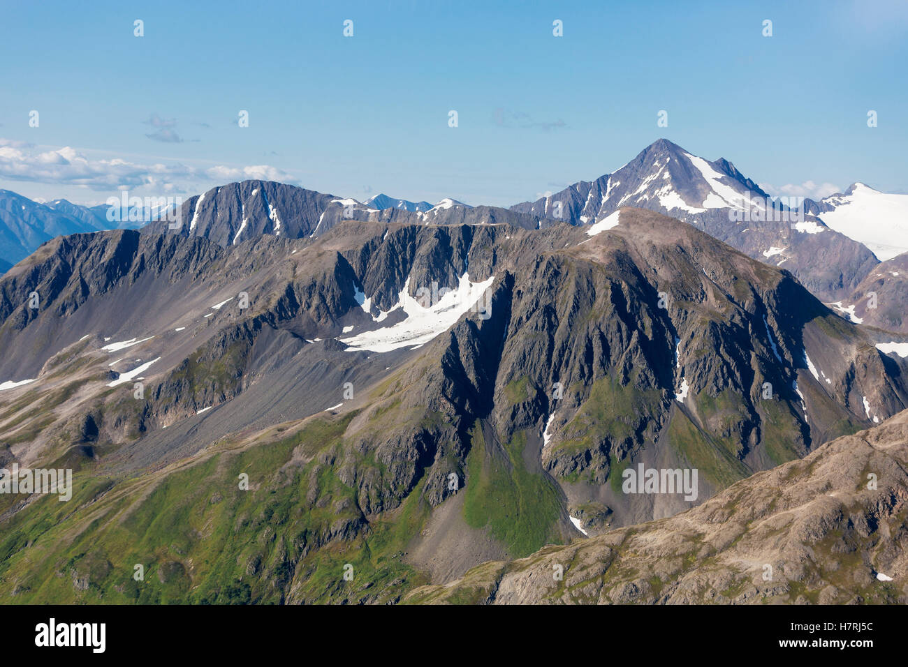 Peak height view of the Kenai Mountains during summer with little snow on the peaks; Seward ...