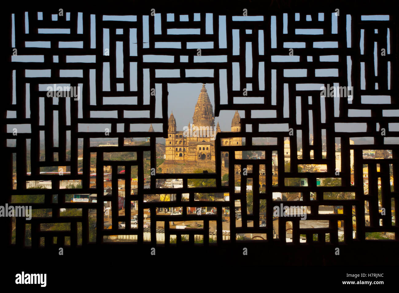 View of temple through carved stone screen window of Rajput palace ...
