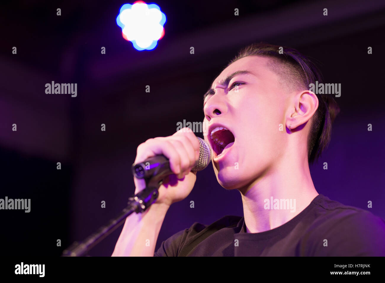 Young Chinese man singing on stage Stock Photo - Alamy