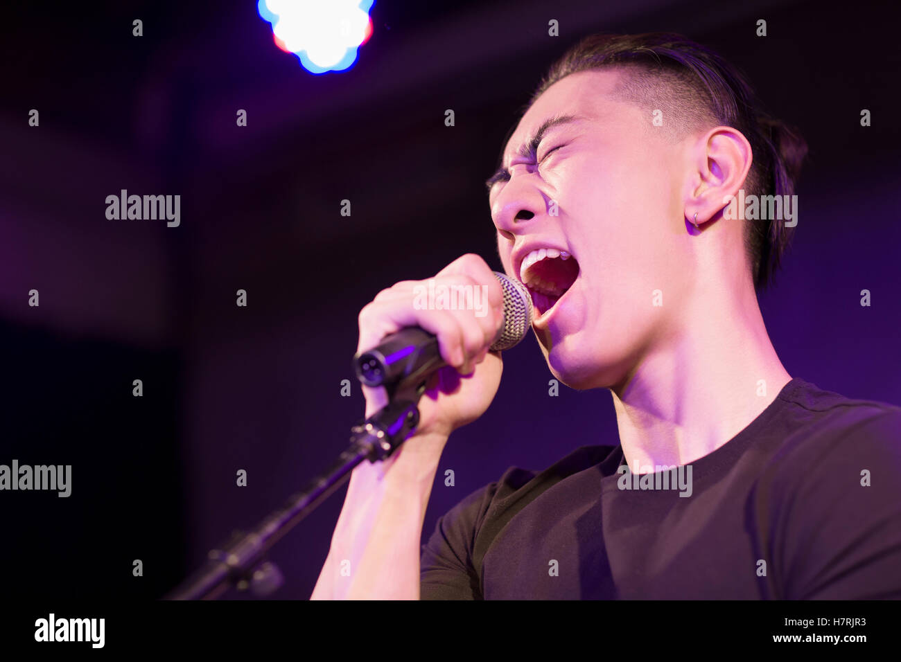 Young Chinese man singing on stage Stock Photo - Alamy