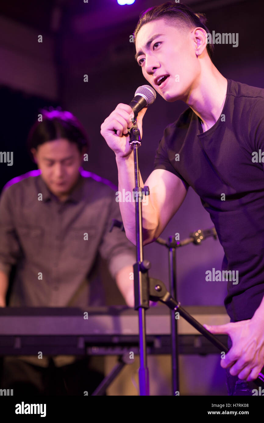 Young Chinese man singing on stage Stock Photo - Alamy